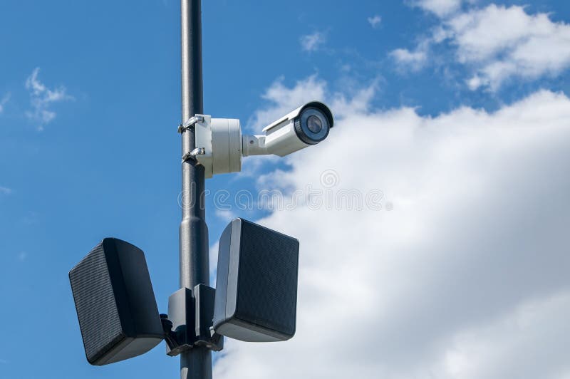 A CCTV Camera is Mounted on a Pillar with a Blue Sky and Clouds in the ...