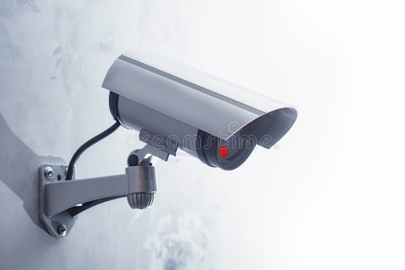 CCTV Security Camera with a Glowing Red Light is Mounted on a Gray Wall ...