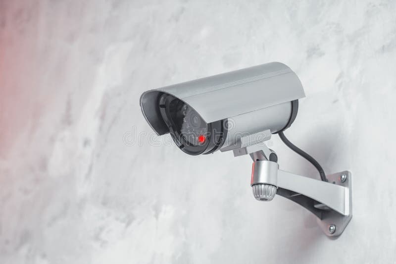 CCTV Security Camera with a Glowing Red Light is Mounted on a Gray Wall ...