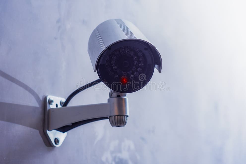 CCTV Security Camera with a Glowing Red Light is Mounted on a Gray Wall ...