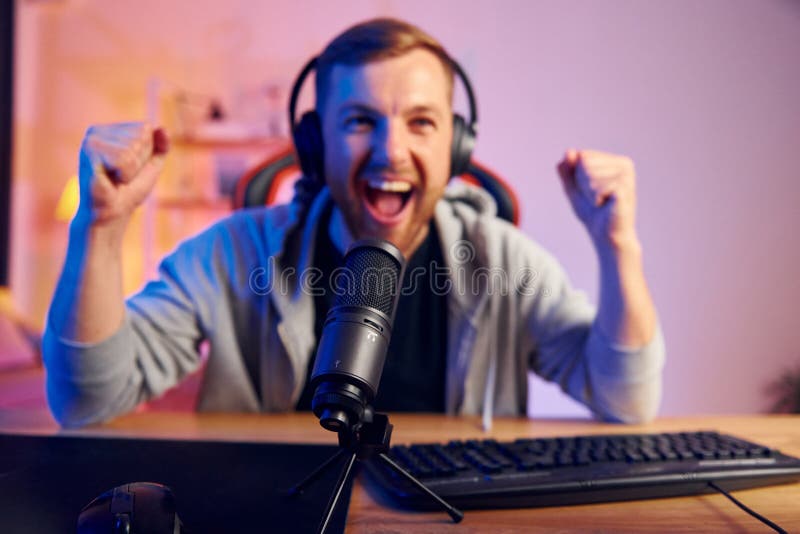 Celebrating Victory. Man in Headphones and with Microphone is Live on ...
