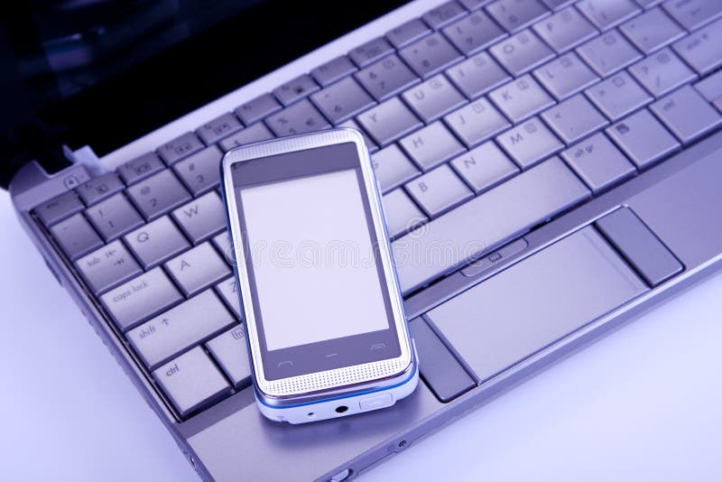Mobile phone on a laptop stock image. Image of mobile - 13483525