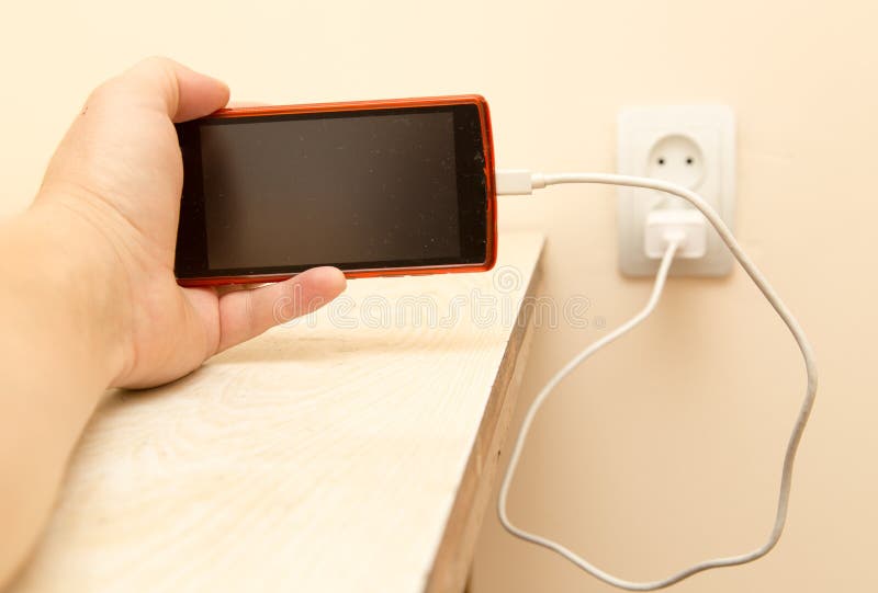 Cell phone charging in your hand - Stock Image - Everypixel
