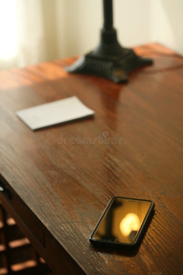 Cell phone on a desk stock image. Image of light, desk - 95780429