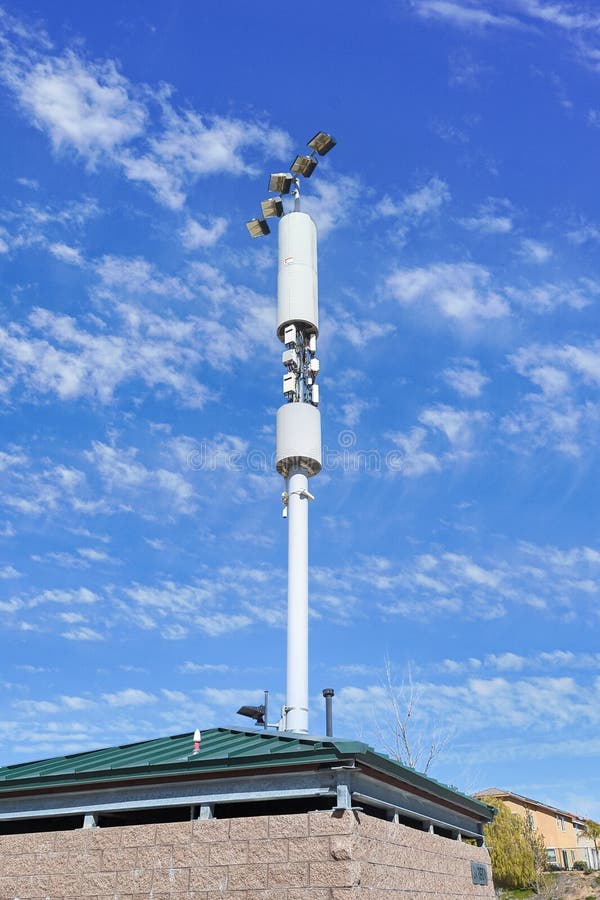 Cell Phone Tower and Light Tower Next To a Sports Field Stock Photo ...