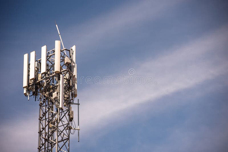 Cell Tower with Multiple Antennas Against a Clear Blue Sky, Symbolizing ...