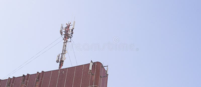 Cellular Antenna on the Roof of a High Building on Blue Sky Background ...