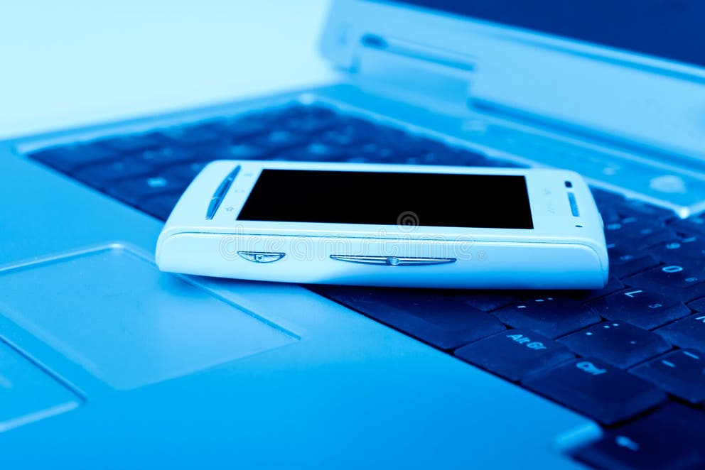 Cellular Phone on Laptop stock photo. Image of electronic - 23202410