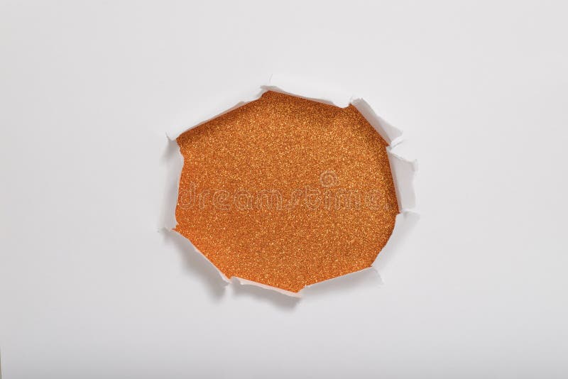 Center Torn Hole in White Paper Revealing a Gold Glitter Texture ...