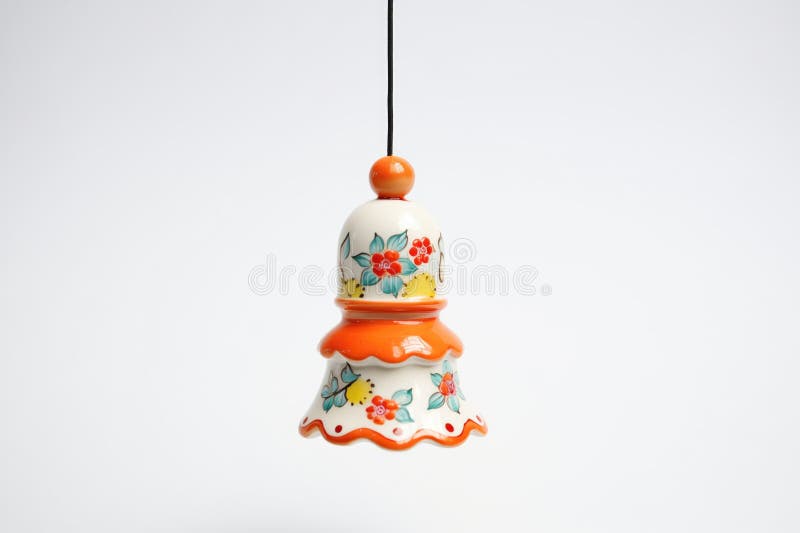 A Ceramic Bell with Painted Details Hanging from a Metal Rod Stock ...