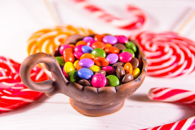 Ceramic Bowl with Colored Candies and Lollipops on a Wooden Table Stock ...