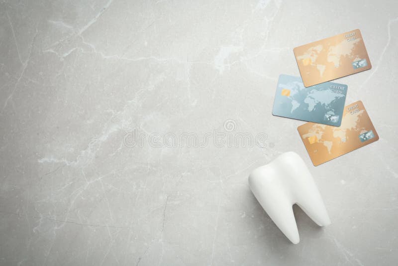 Ceramic Model of Tooth and Credit Cards on Light Grey Table, Flat Lay ...