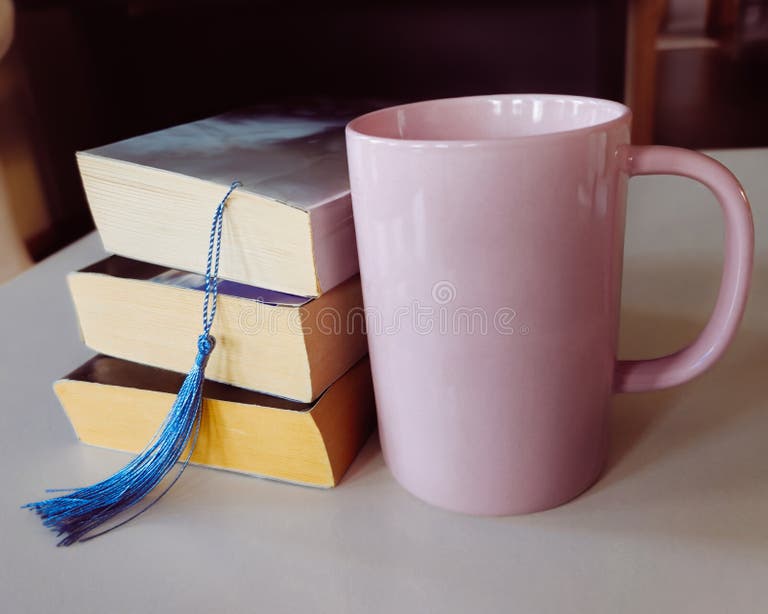 Ceramic Mug by a Stack of Books on a White Surface or Table with ...
