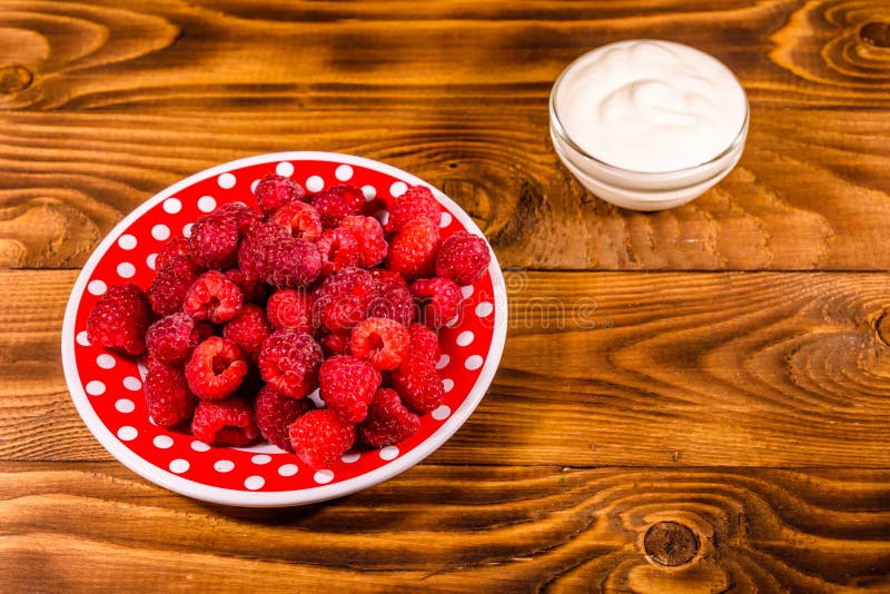 Ceramic Plate with Ripe Raspberries and Sour Cream on Wooden Table ...