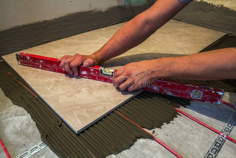 Ceramic Tiles and Tools for Tiler. Worker Hand Installing Floor Stock ...