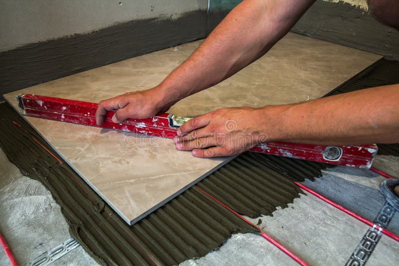 Ceramic Tiles and Tools for Tiler. Worker Hand Installing Floor Stock ...