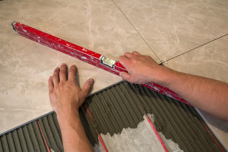 Ceramic Tiles and Tools for Tiler. Worker Hand Installing Floor Tiles ...
