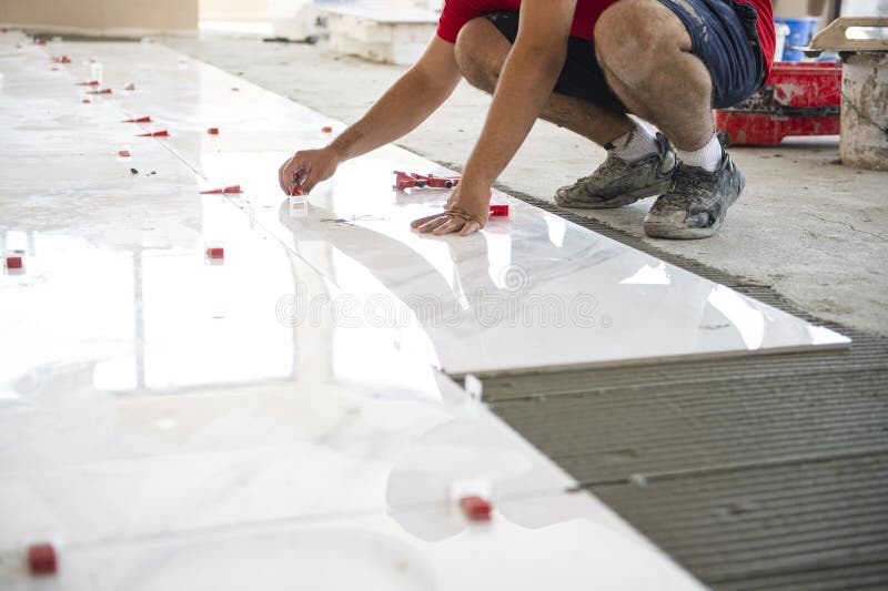 Ceramic White Floor Tiles Laid Over Adhesive with a Tile Leveling ...
