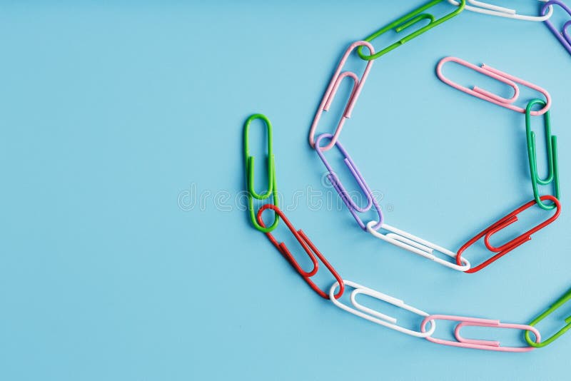 A Chain of Multi-colored Paper Clips on a Blue Background Stock Photo ...