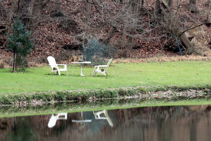 The Chairs Reflection in the Pond. Stock Photo - Image of pondwhi ...
