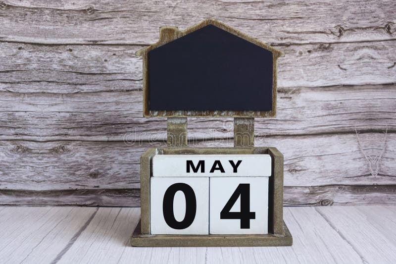 Chalkboard with May 04 Date on White Cube Block on Wooden Table. Stock ...