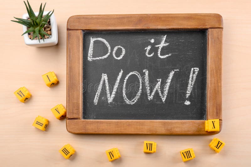 Chalkboard with Phrase "Do it Now " and Stationery on Table. Time ...