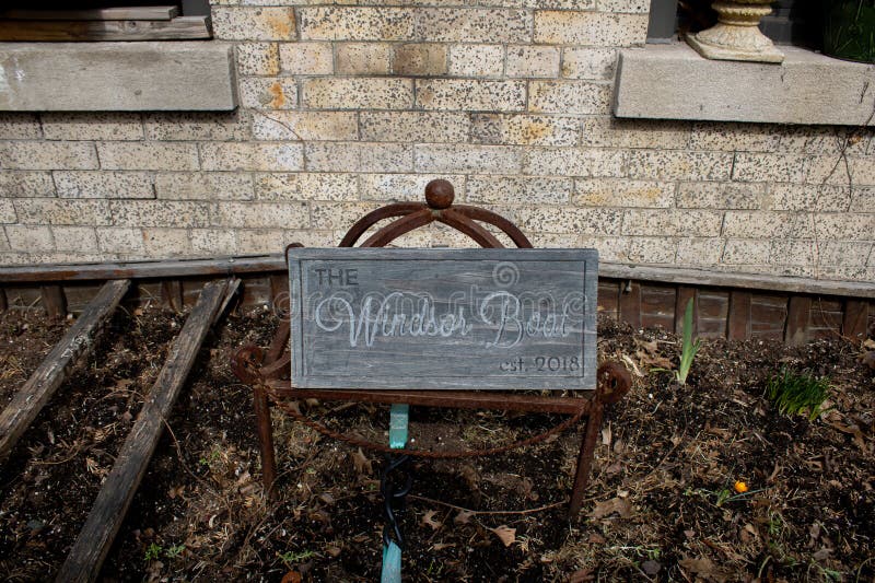 A Chalkboard Sits Next To Some Railroad Tracks Next To a Brick Building ...