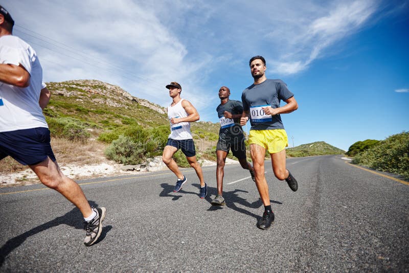 Challenging One Another on the Road. a Group of Young Men Running a ...