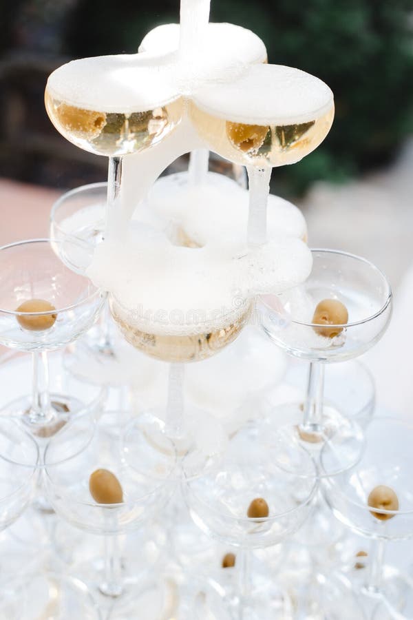 Champagne is Poured into a Wine Slide with Olives in Glasses Stock ...