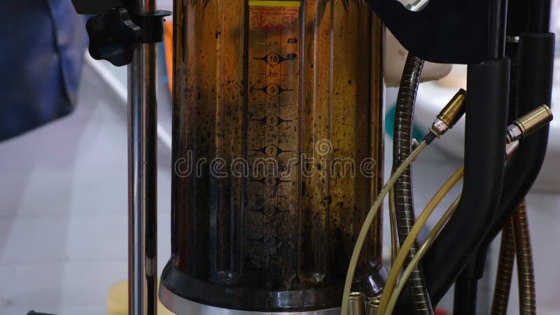 Change Engine Oil. Draining the Old Oil from the Car into a Special ...