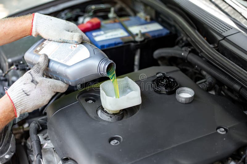 Changing the Oil in a Car Engine. a Car Mechanic Pours Engine Oil ...