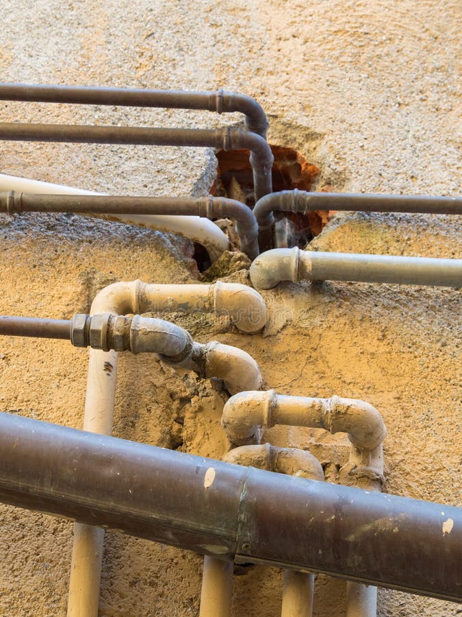 Chaotic Overlapping Pipes on a Plastered Ocher Wall Color Stock Image ...