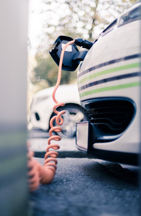 Charching an Electric Car with Power Cable Supply, Plugged in Stock ... Charching an Electric Car with Power Cable Supply, Plugged in Stock ...
