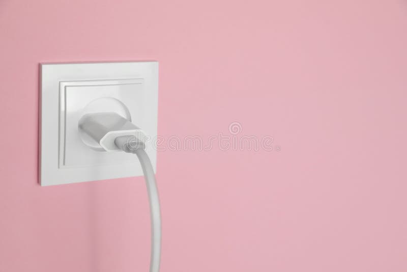 Charger Adapter Plugged into Power Socket on Pink Wall, Space for Text ...
