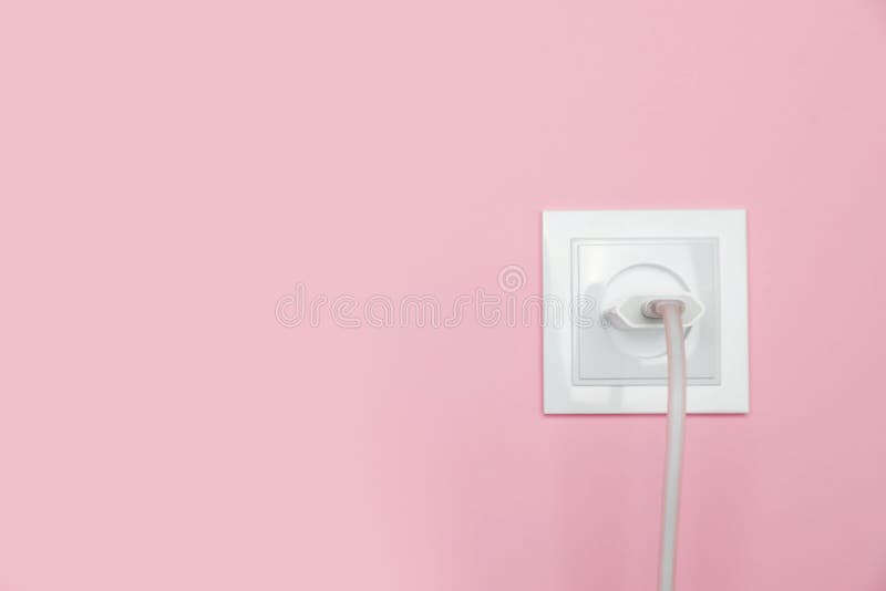 Charger Adapter Plugged into Power Socket on Pink Wall, Space for Text ...