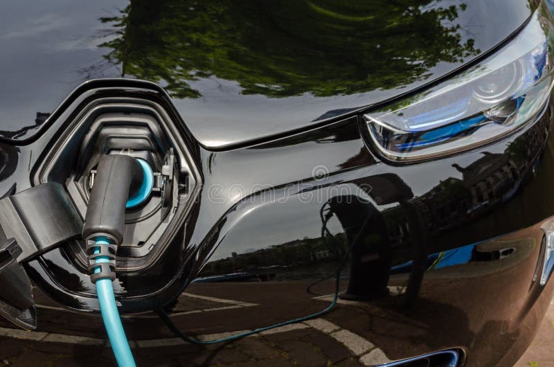 Charging Modern Electric Car with Power Supply Plugged in Stock Photo ...