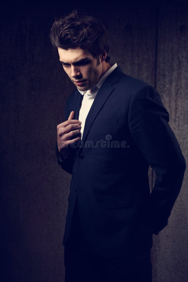 Male Model Posing In White Underwear In Dark Shadow Background With