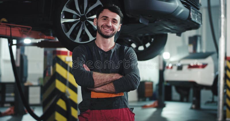 Charismatic Mechanic Guy in the Uniform in Front of the Camera Looking ...
