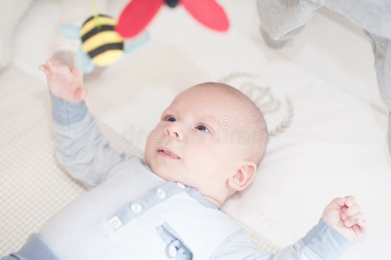 Charming Baby Playing with a Toy Lying on Back Stock Photo - Image of ...