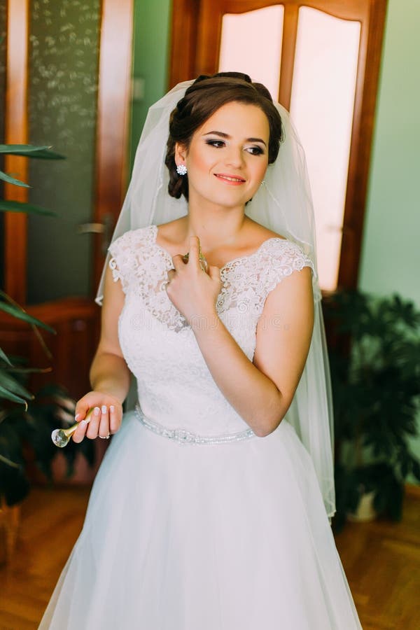 Charming Bride in Gorgeous White Dress Using Perfume before Wedding ...