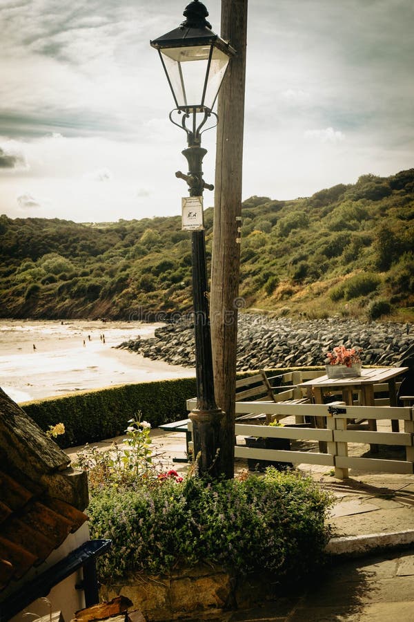 Charming Coastal Scene with a Vintage Lamp Post Overlooking a Sandy ...
