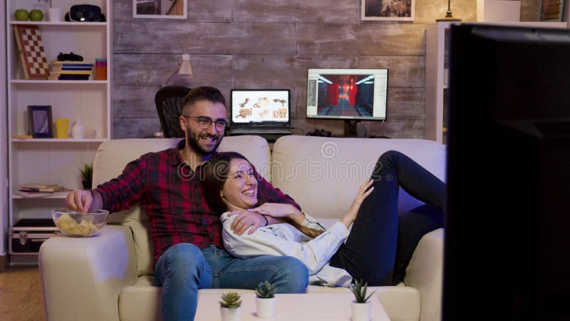 Charming Couple Lying on the Couch Watching a Movie Stock Photo - Image ...