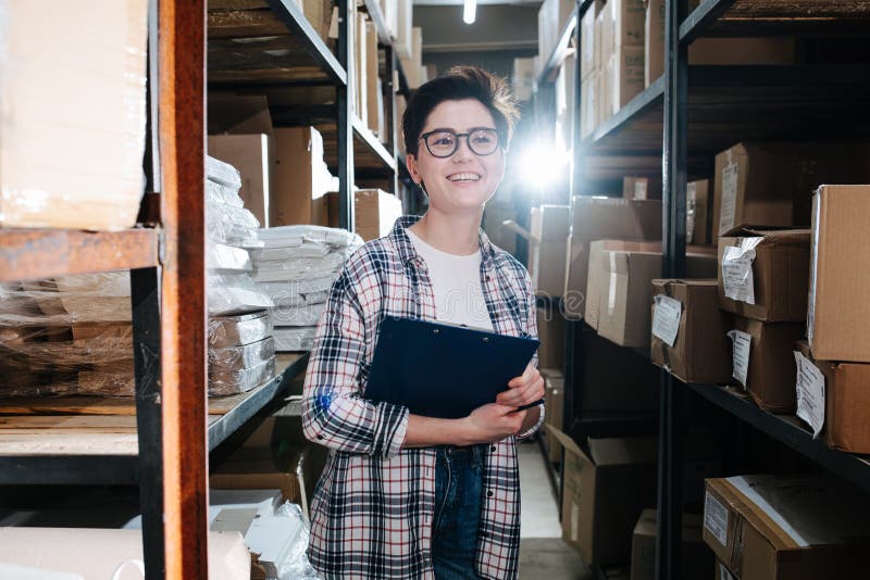 Charming Female Warehouse Distribution Worker Holding a Clipboard Stock ...