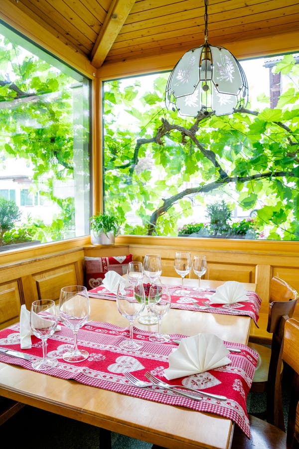 Charming and Inviting Restaurant Table with a Bay Window and Grapevines ...