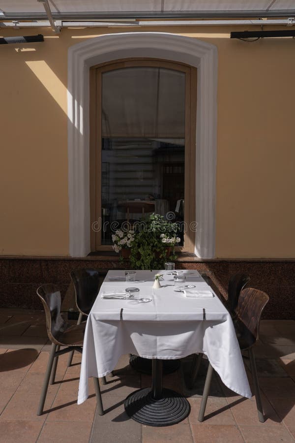 A Charming Outdoor Dining Setup Featuring an Elegant Table and Inviting ...