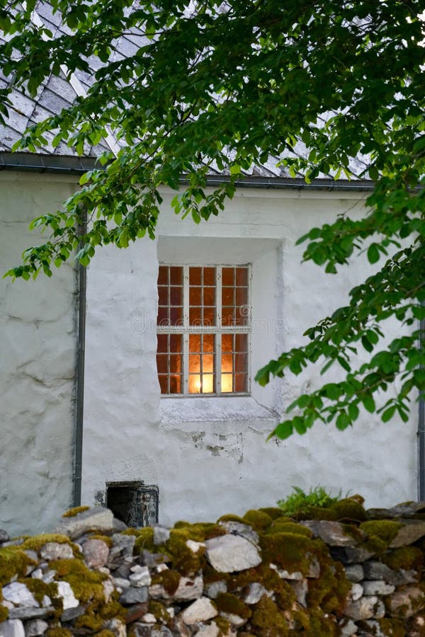 A Charming Window with Warm Light Glowing Inside an Old Stone Building ...