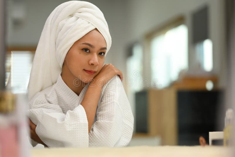 Charming Woman in Bathrobe Looking at Her Reflection in Mirror and ...