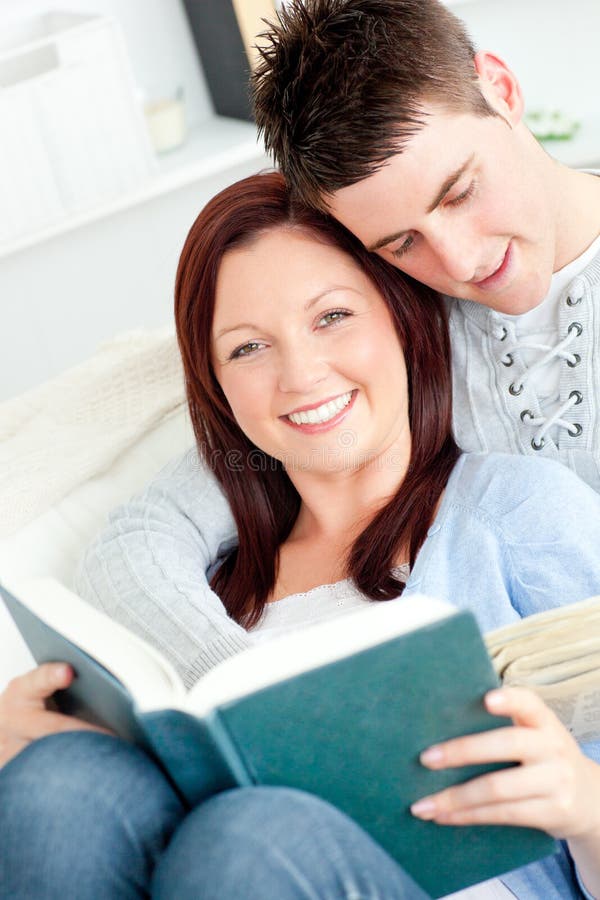 Charming Young Couple Reading a Book on the Sofa Stock Photo - Image of ...
