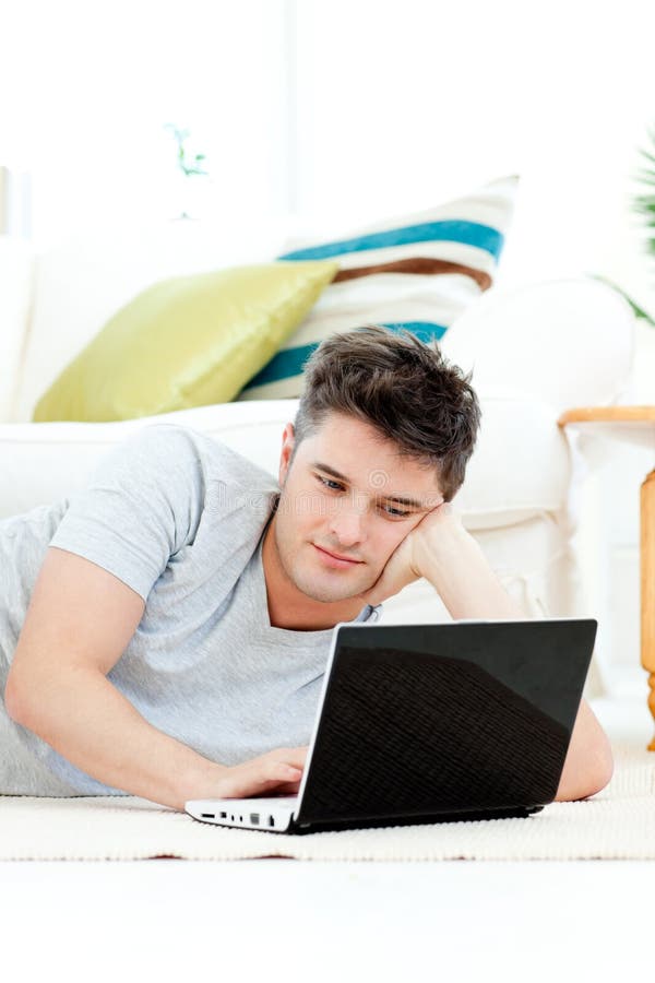 Charming Young Man Using His Laptop on the Floor Stock Photo - Image of ...