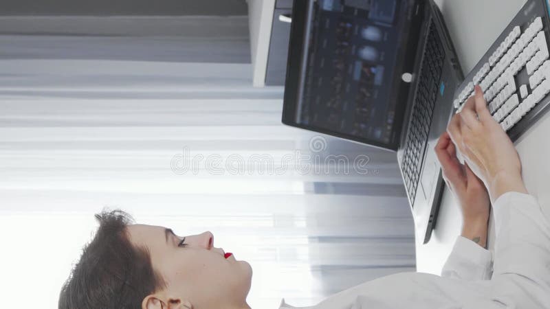 Charming Young Woman Multitasking with Two Computers in a Bright Home ...